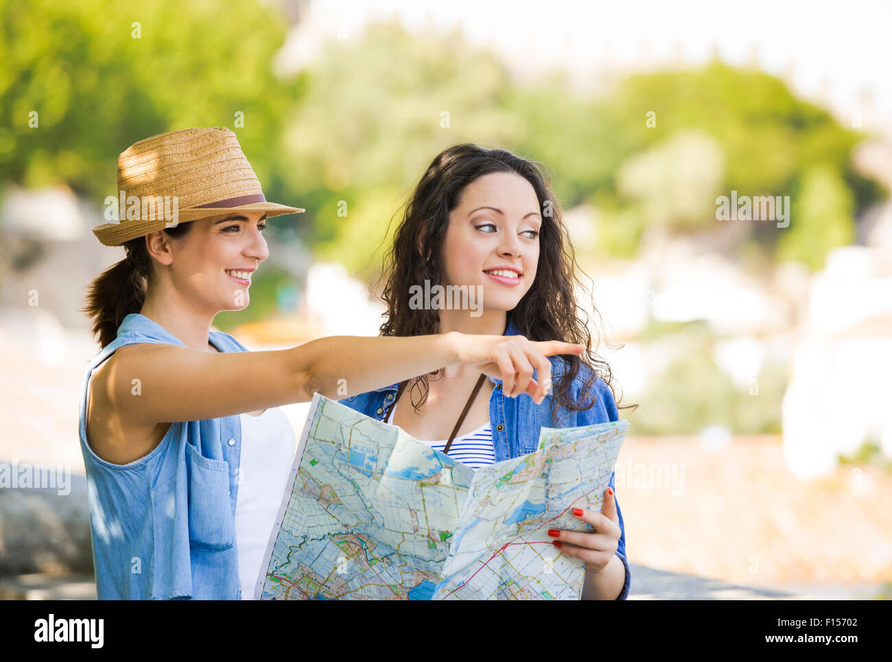 Two beautiful female friends searching a place on the map Stock Photo ...