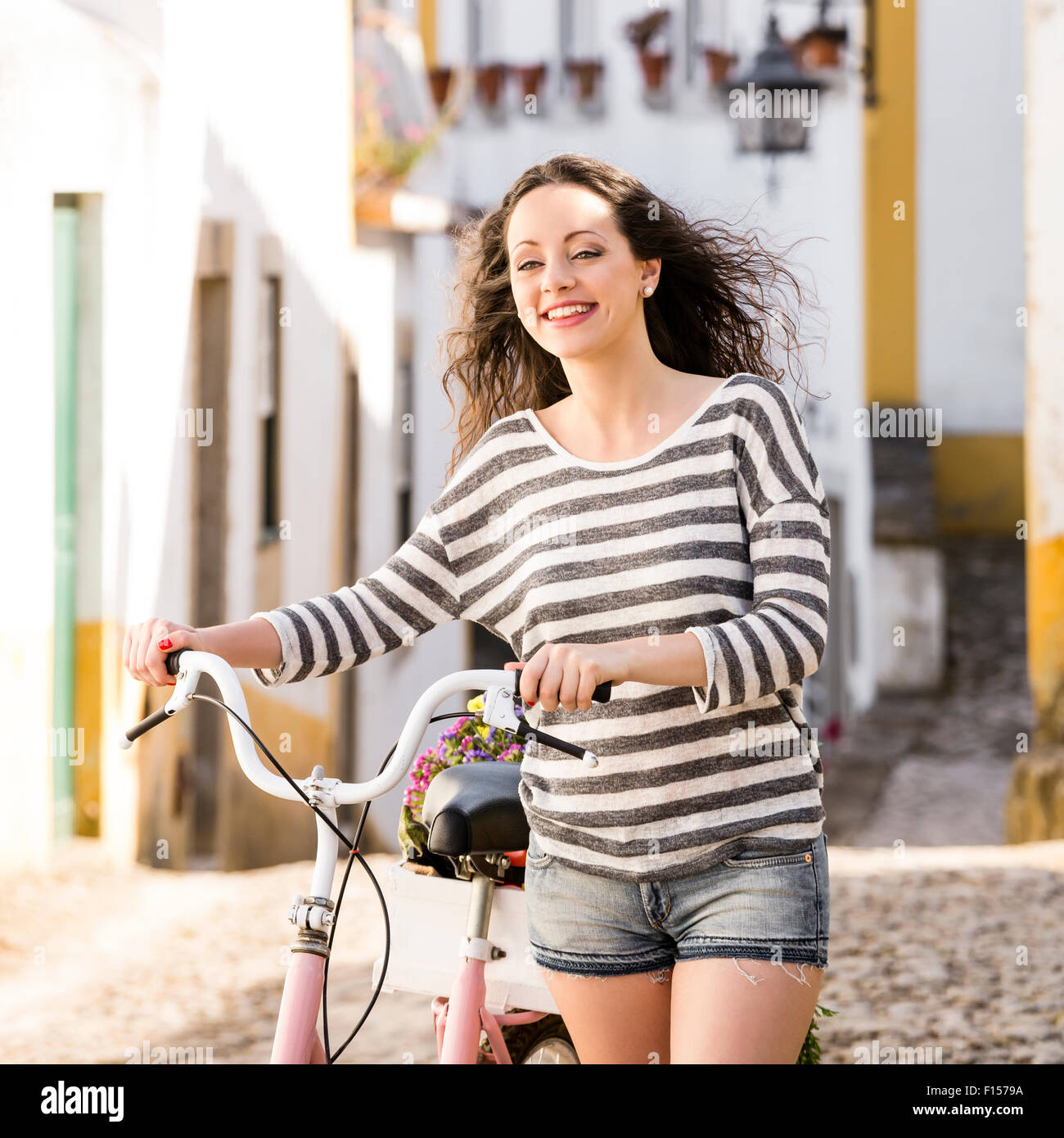 Happy beautiful female tourist riding a bicycle Stock Photo - Alamy