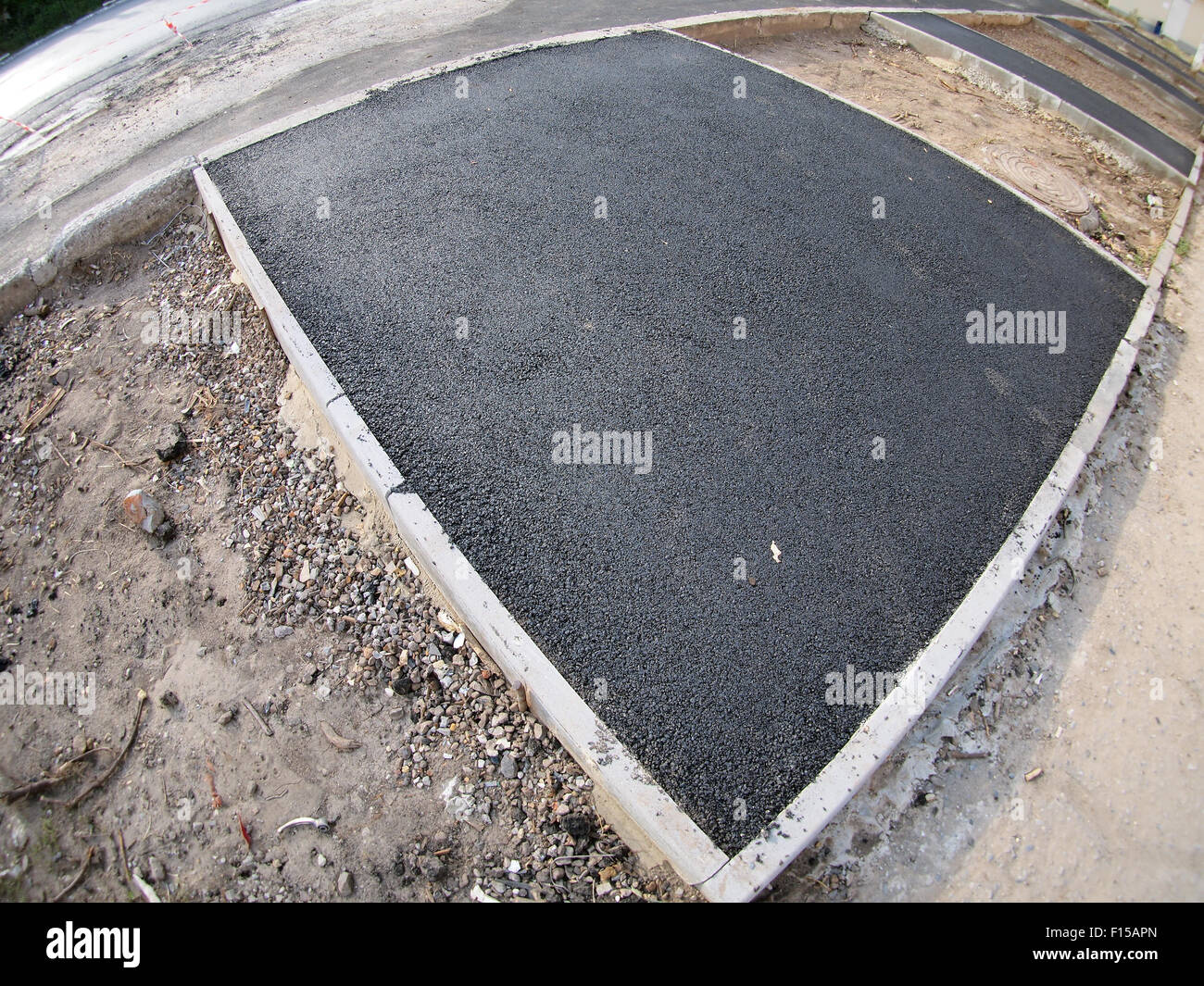 The fresh, black, just laid asphalt at the construction site with wide ...