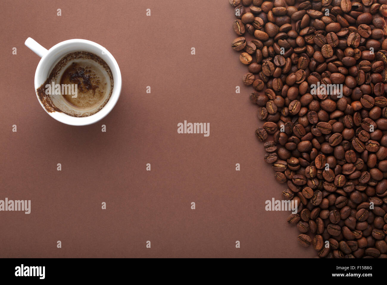 Cup of drunk coffee with coffee beans on brown background.Above view ...