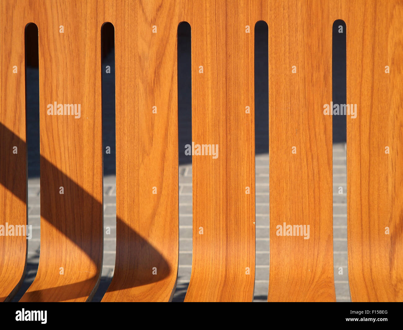Fragment of a wooden outdoor benches closeup with shadow from the sun ...