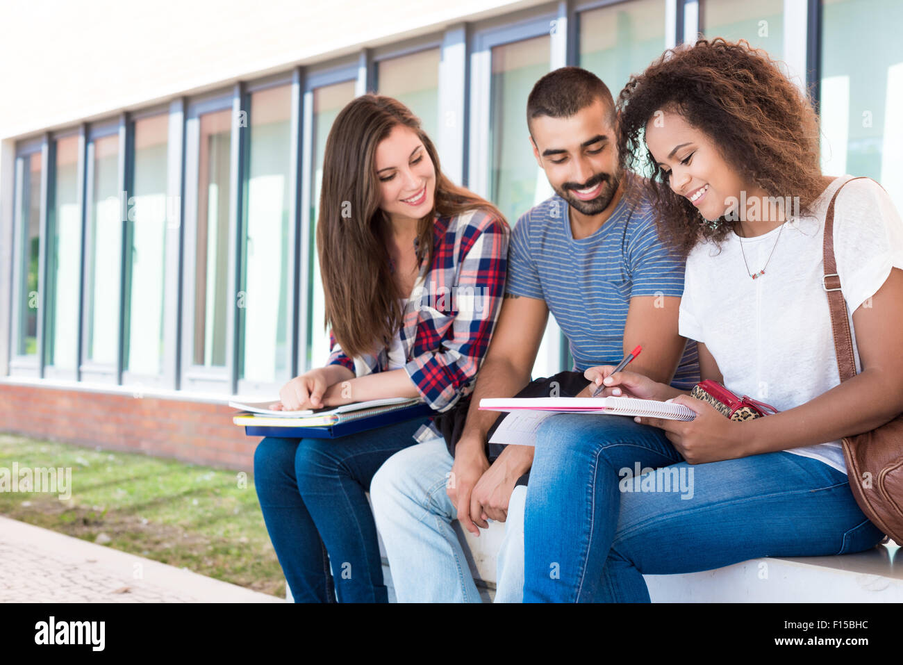 Students sharing notes in the university campus Stock Photo - Alamy