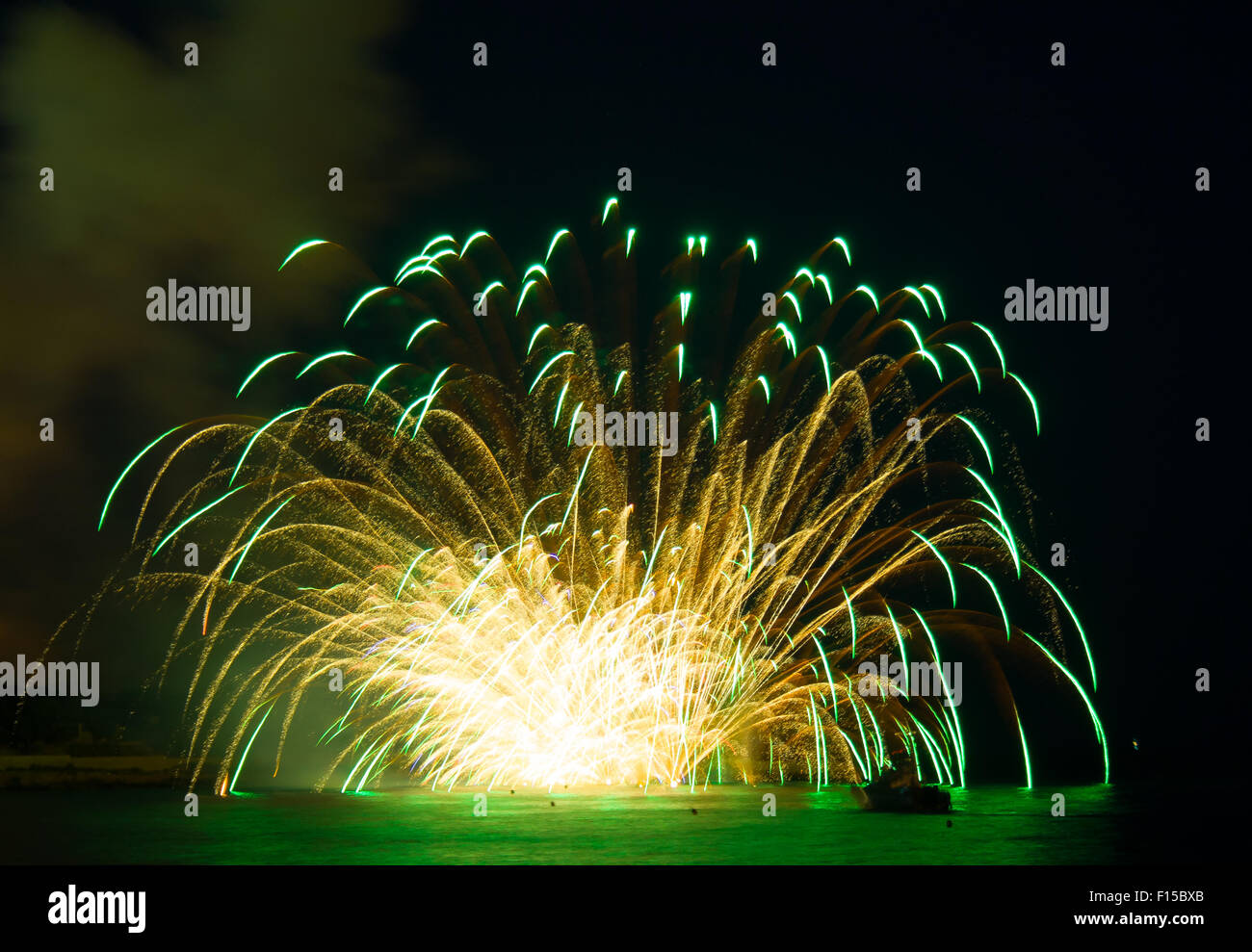 green and yellow Fireworks over the sea and Reflecting in Water Stock ...