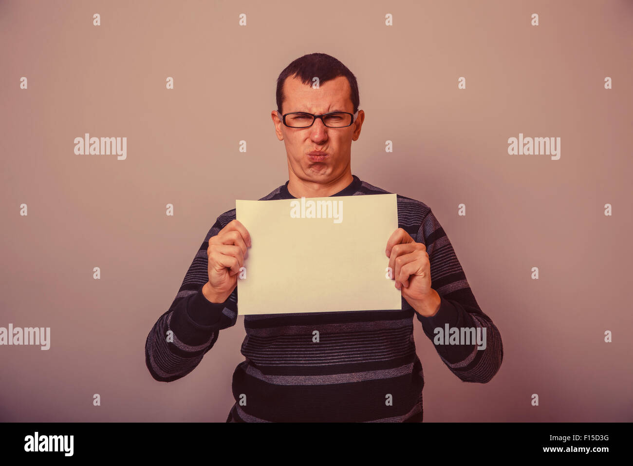 European-looking man of 30 years holding a blank sheet of discon Stock ...