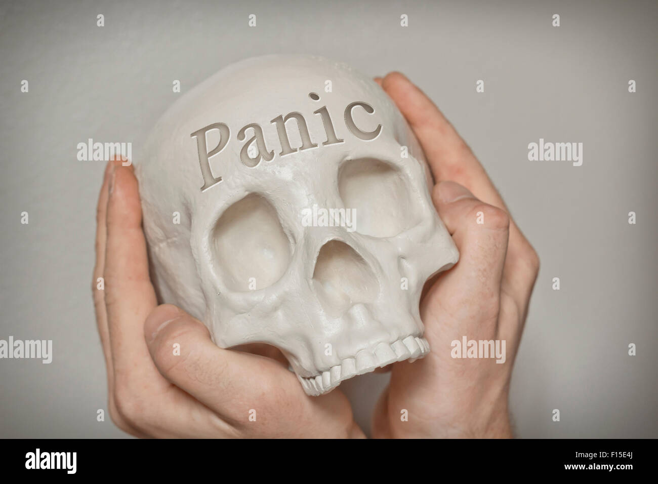 Engraved word panic on skull forehead with hands clasping to emphasize ...
