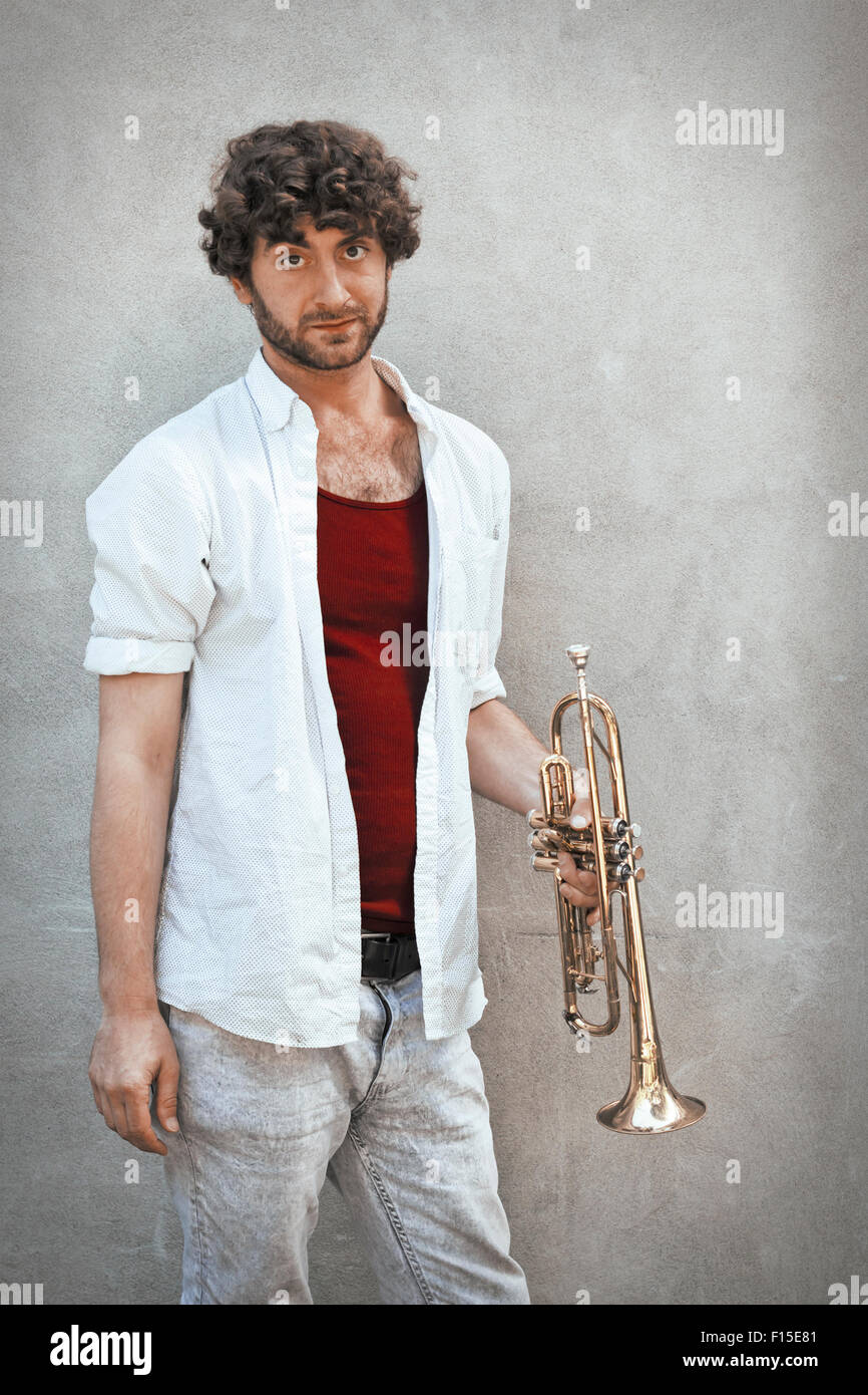 Curly haired man plays jazz trumpet outside Stock Photo - Alamy