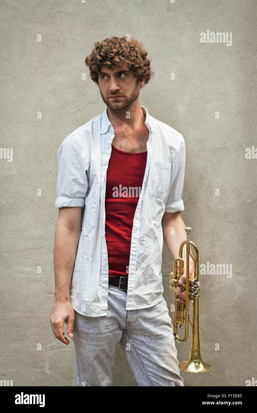 Curly haired man plays jazz trumpet outside Stock Photo - Alamy