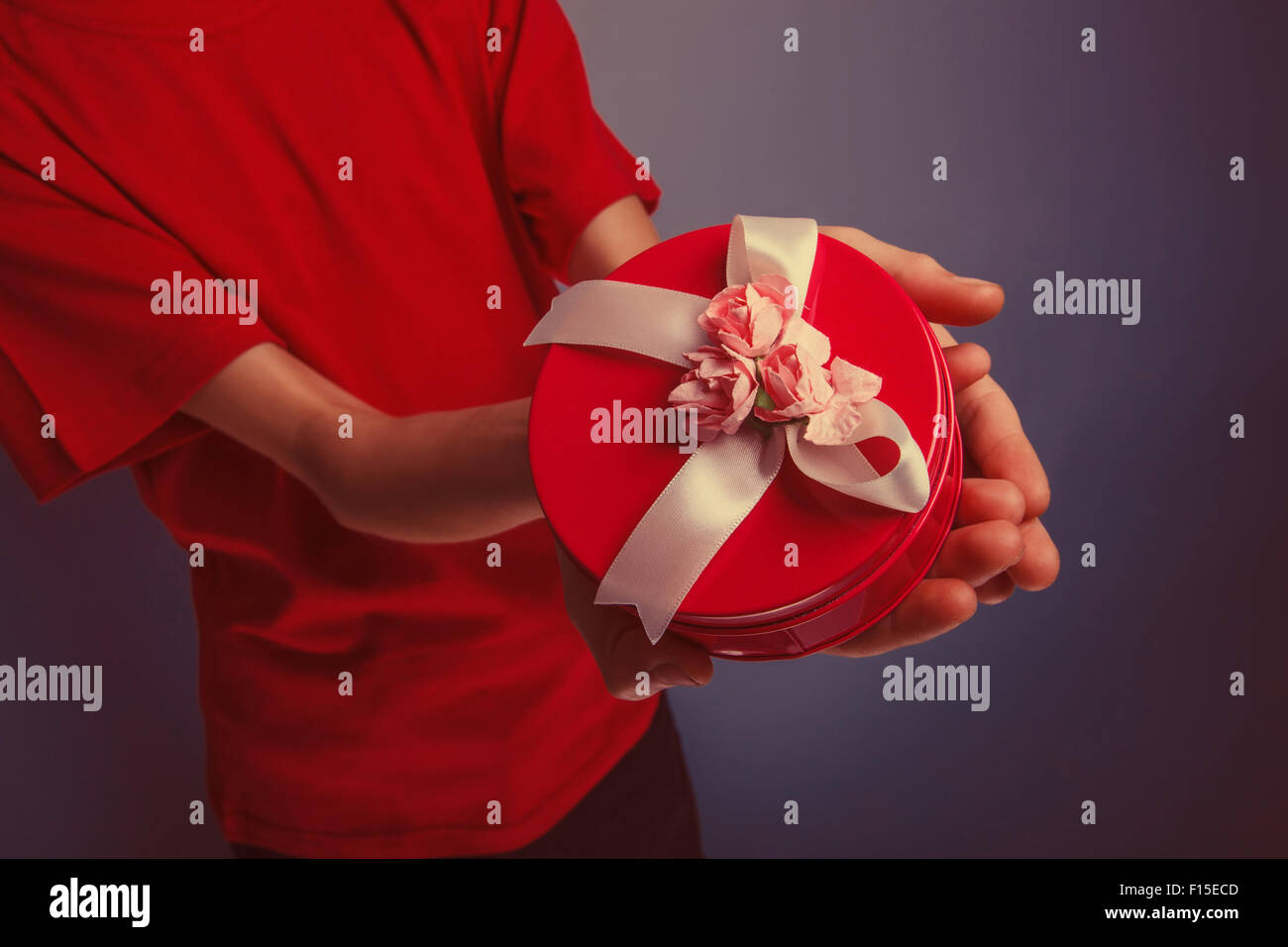 gift in a box in his hands on gray background retro Stock Photo - Alamy