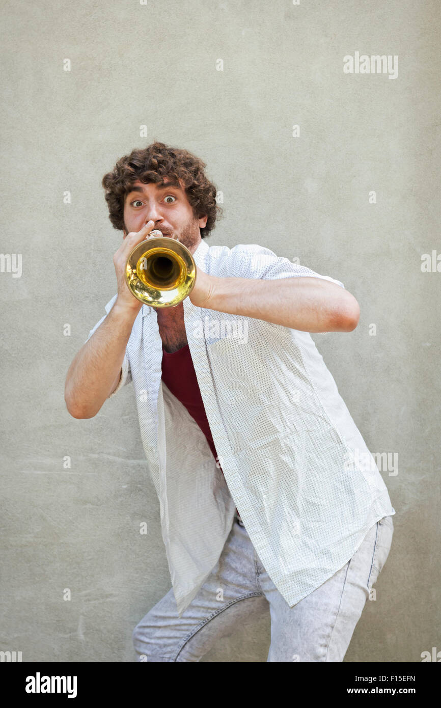 Curly haired man plays jazz trumpet outside Stock Photo - Alamy