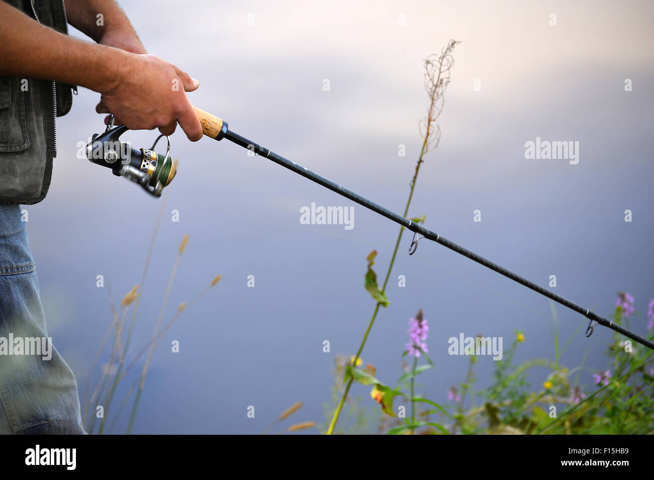 Fishing in river. A fisherman with a fishing rod on the river bank. Man ...