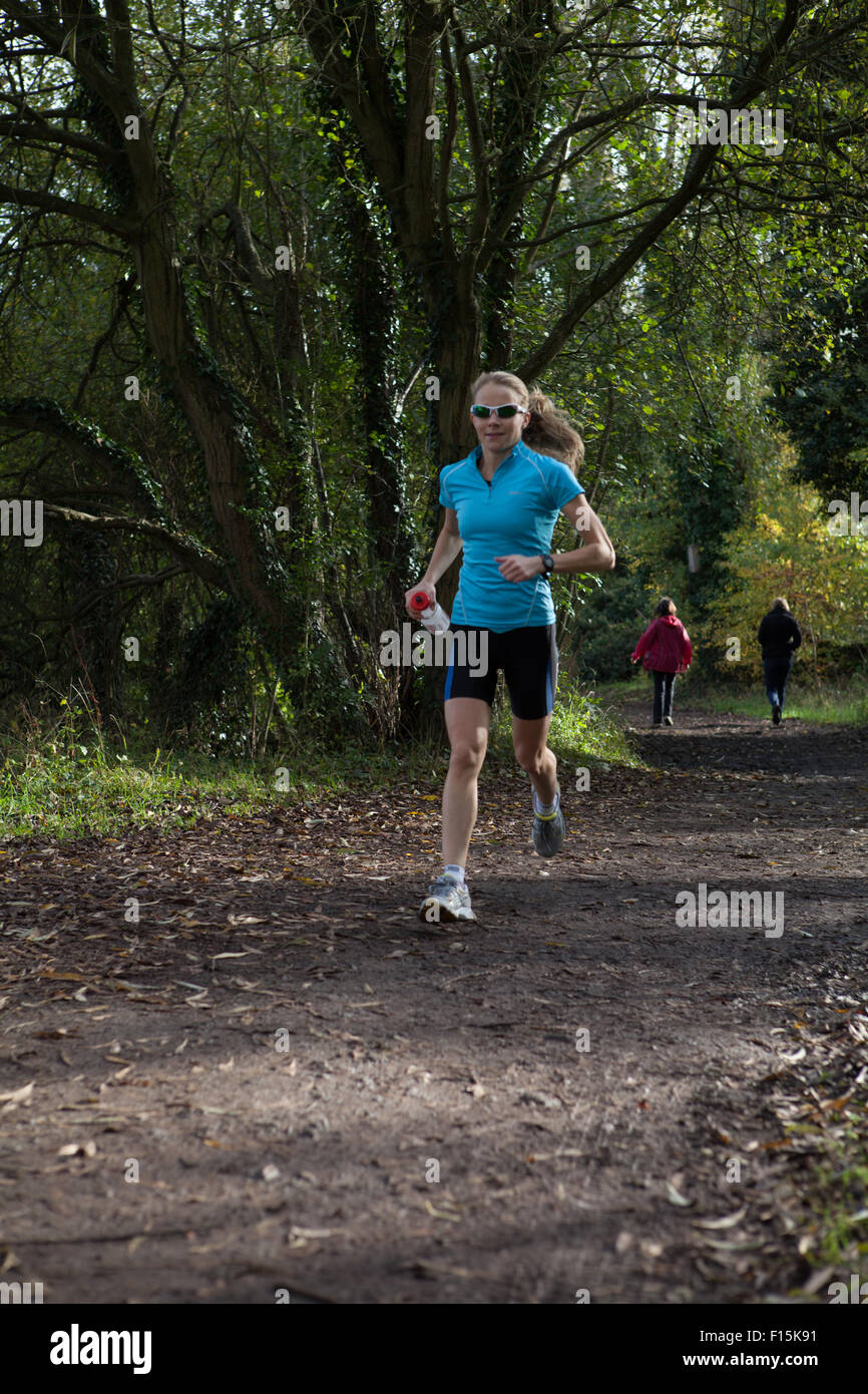 Female running along rural trail in woodland landscape Stock Photo - Alamy