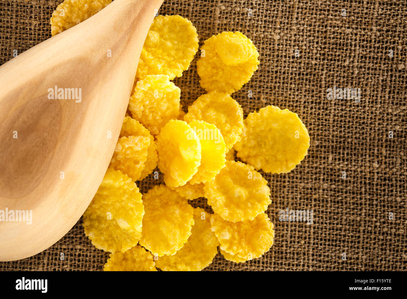 Wooden spoon and corn flakes on sack background closeup Stock Photo - Alamy