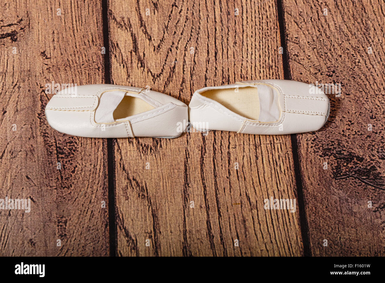 The first ballet position. Children Gym shoes on a wooden floor. The ...