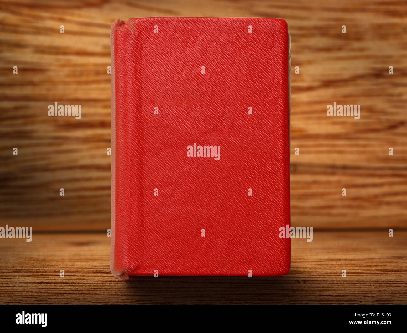 Old red book on wooden background closeup Stock Photo - Alamy
