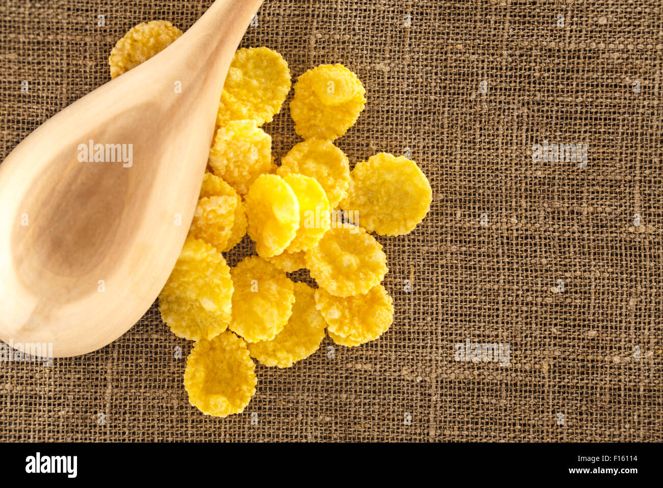 Wooden spoon and corn flakes on sack background closeup Stock Photo - Alamy