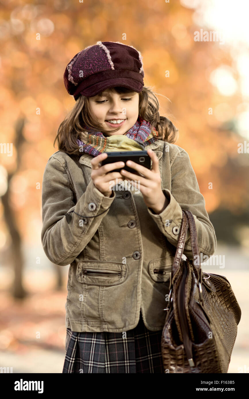 vertical photo, stylish beautiful little girl hold mobile phone Stock ...