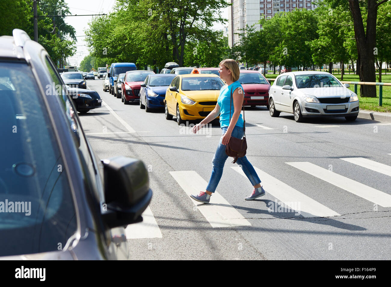 Woman crossing the street at a pedestrian crossing Stock Photo - Alamy