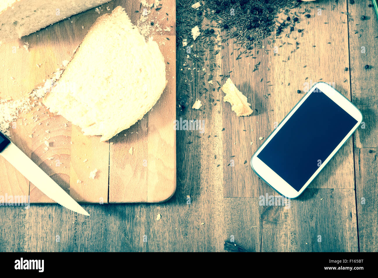 Retro picture of a smartphone lying in a natural kitchen with white ...