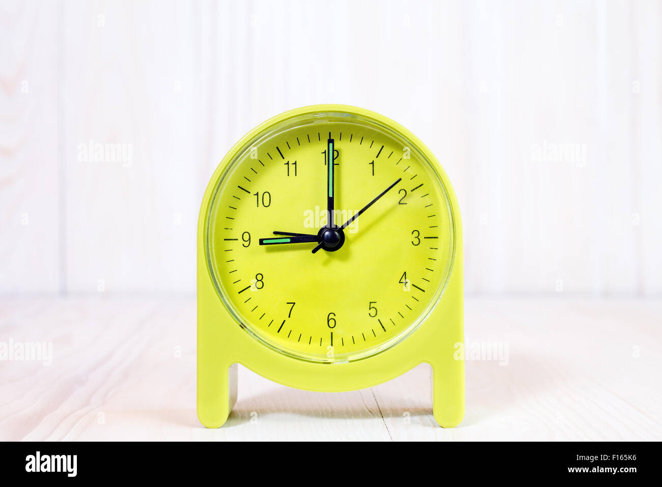 Green alarm clock on the wood background Stock Photo - Alamy