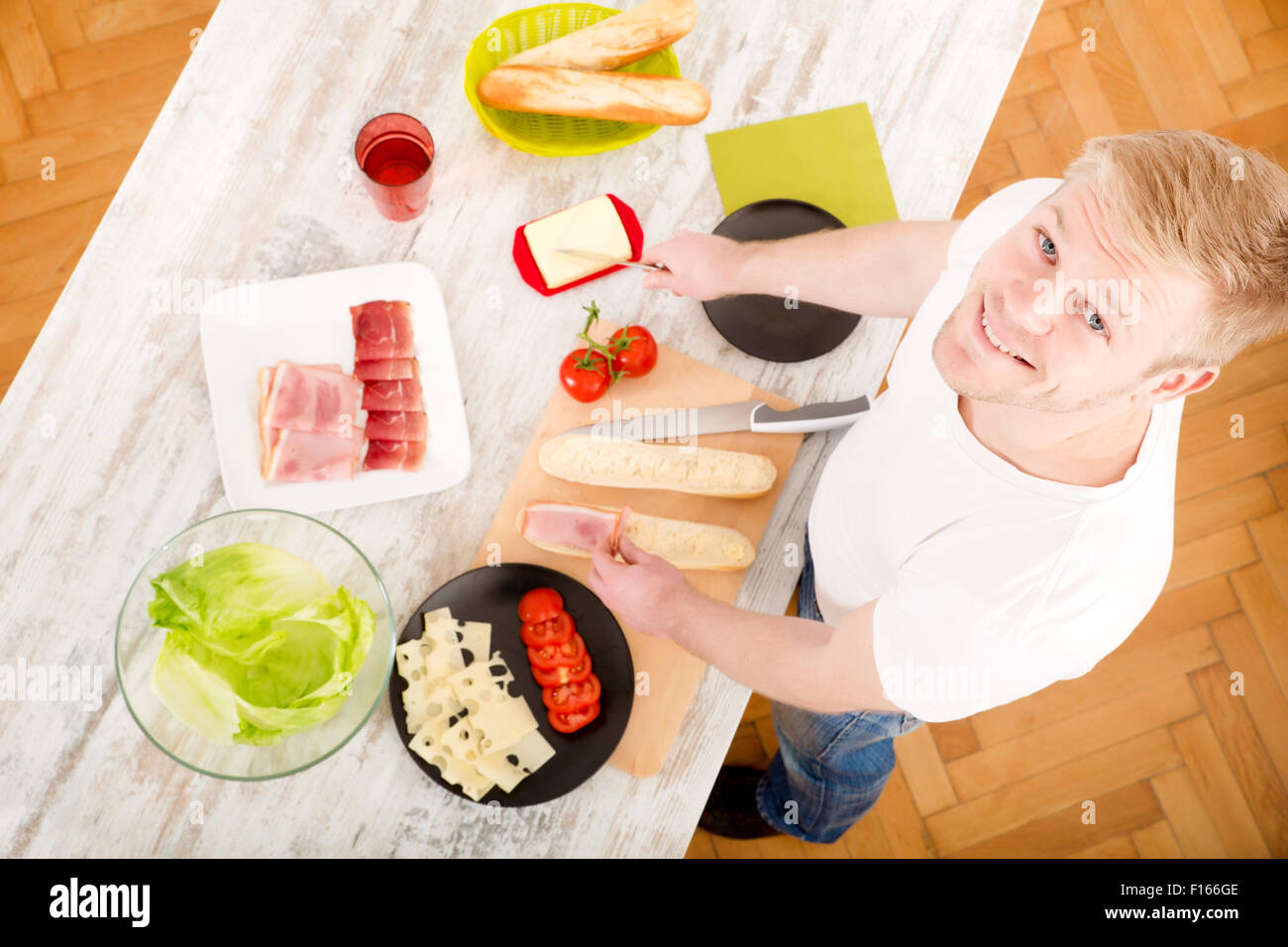A young man preparing a sandwich in the kitchen Stock Photo - Alamy