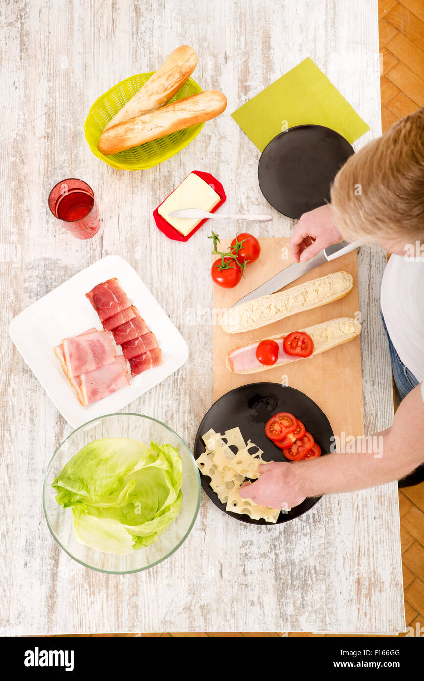 A young man preparing a sandwich in the kitchen Stock Photo - Alamy