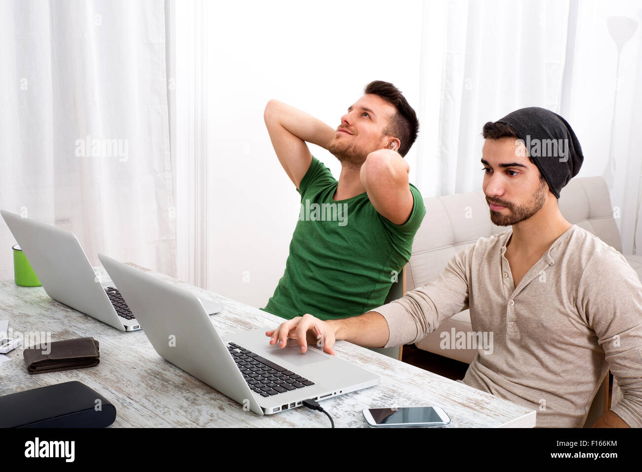 Two workmates teaming up and working together Stock Photo - Alamy