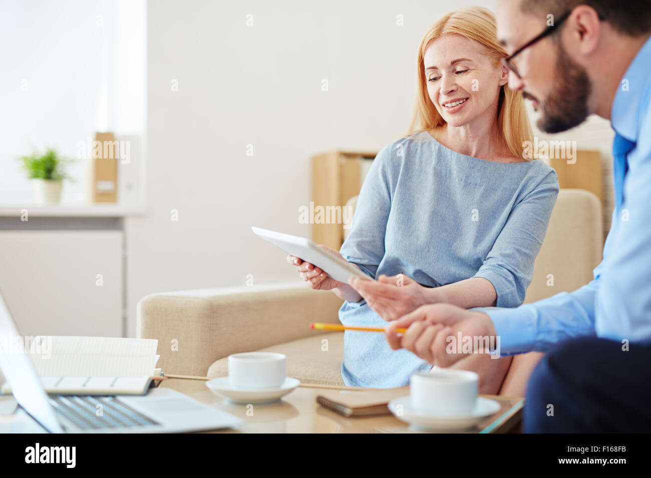 Manager talking to client in receiving room Stock Photo - Alamy