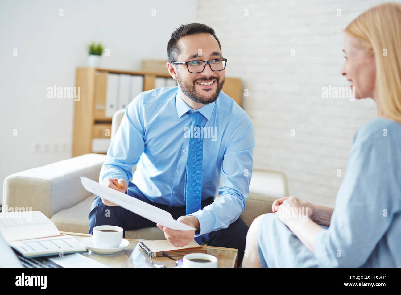 Manager giving contract to his client Stock Photo - Alamy