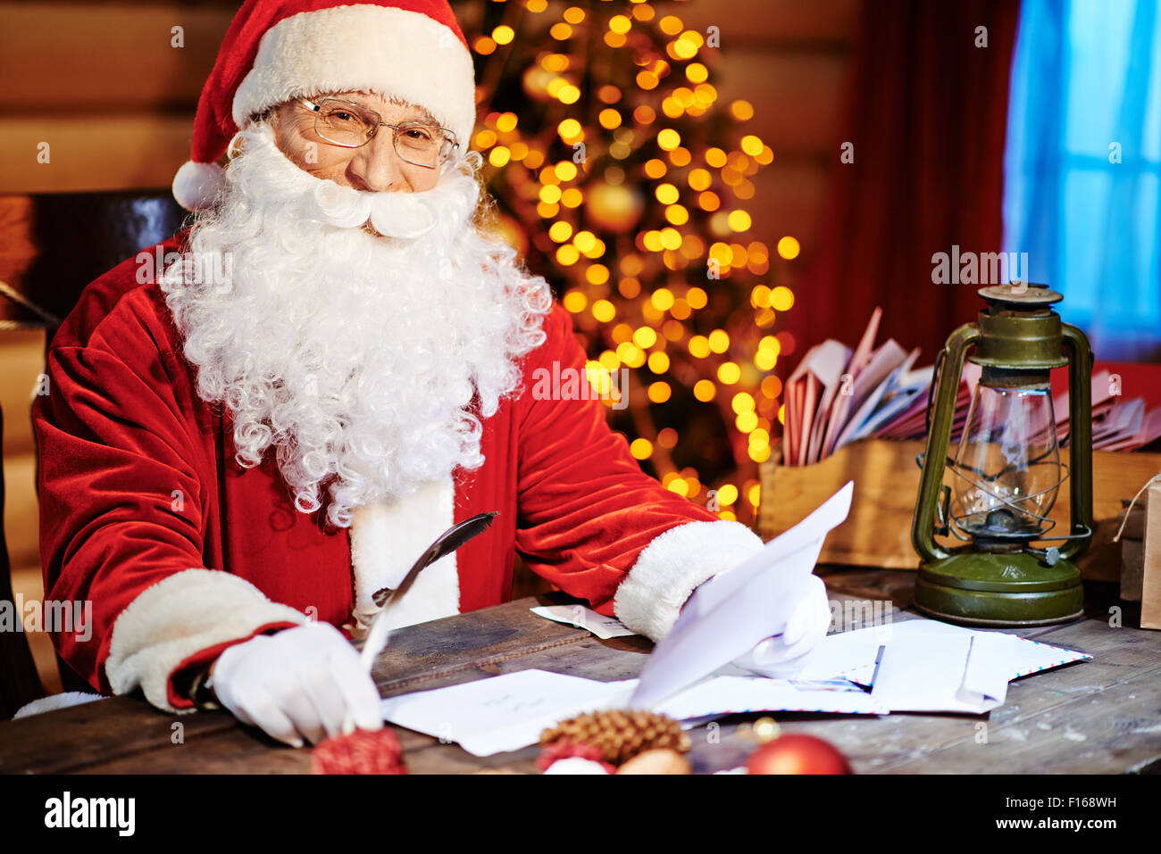 Santa Claus looking at camera while reading Christmas letter Stock ...