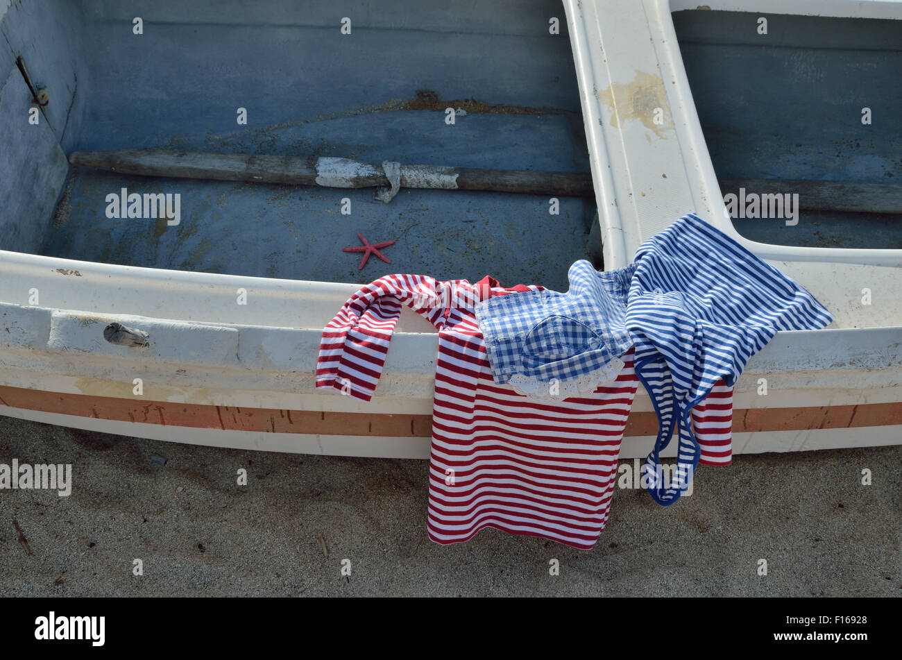 Navy look shirts on a boat with sea star and paddle Stock Photo - Alamy
