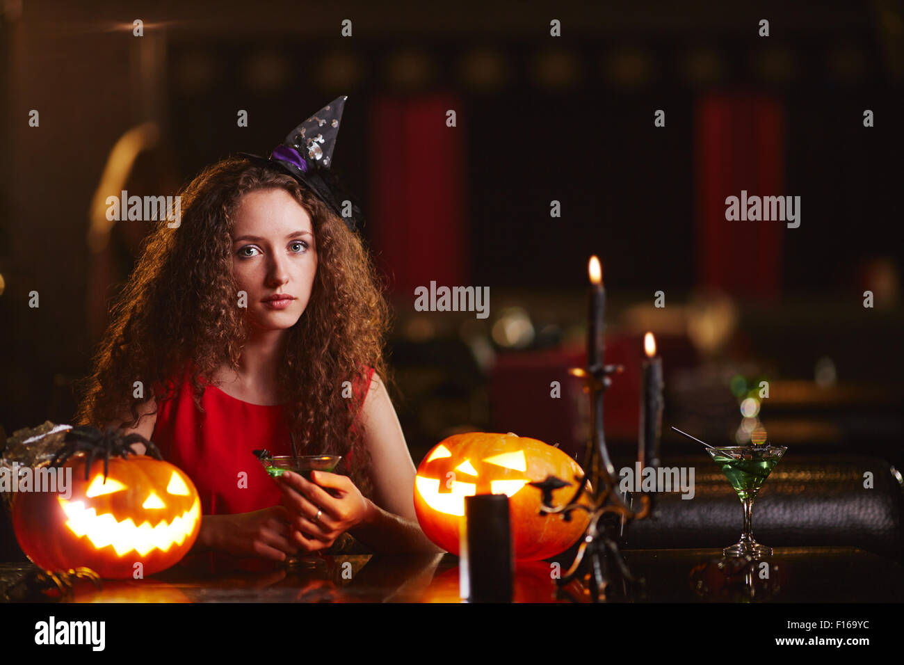 Beautiful witch with martini Stock Photo - Alamy