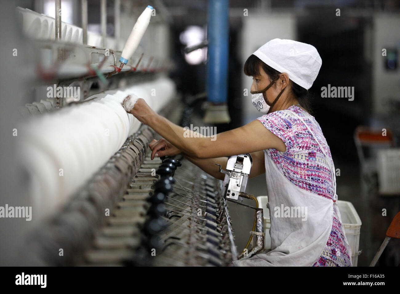 A labour works in a textile factory in Huaibei, Anhui province, China ...