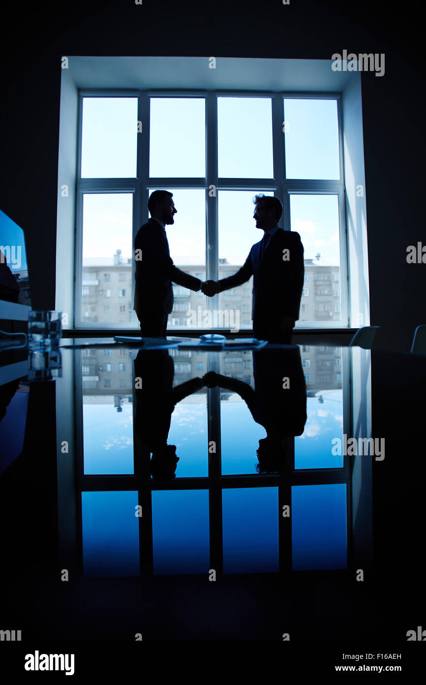 Young businessmen greeting one another by handshake Stock Photo - Alamy