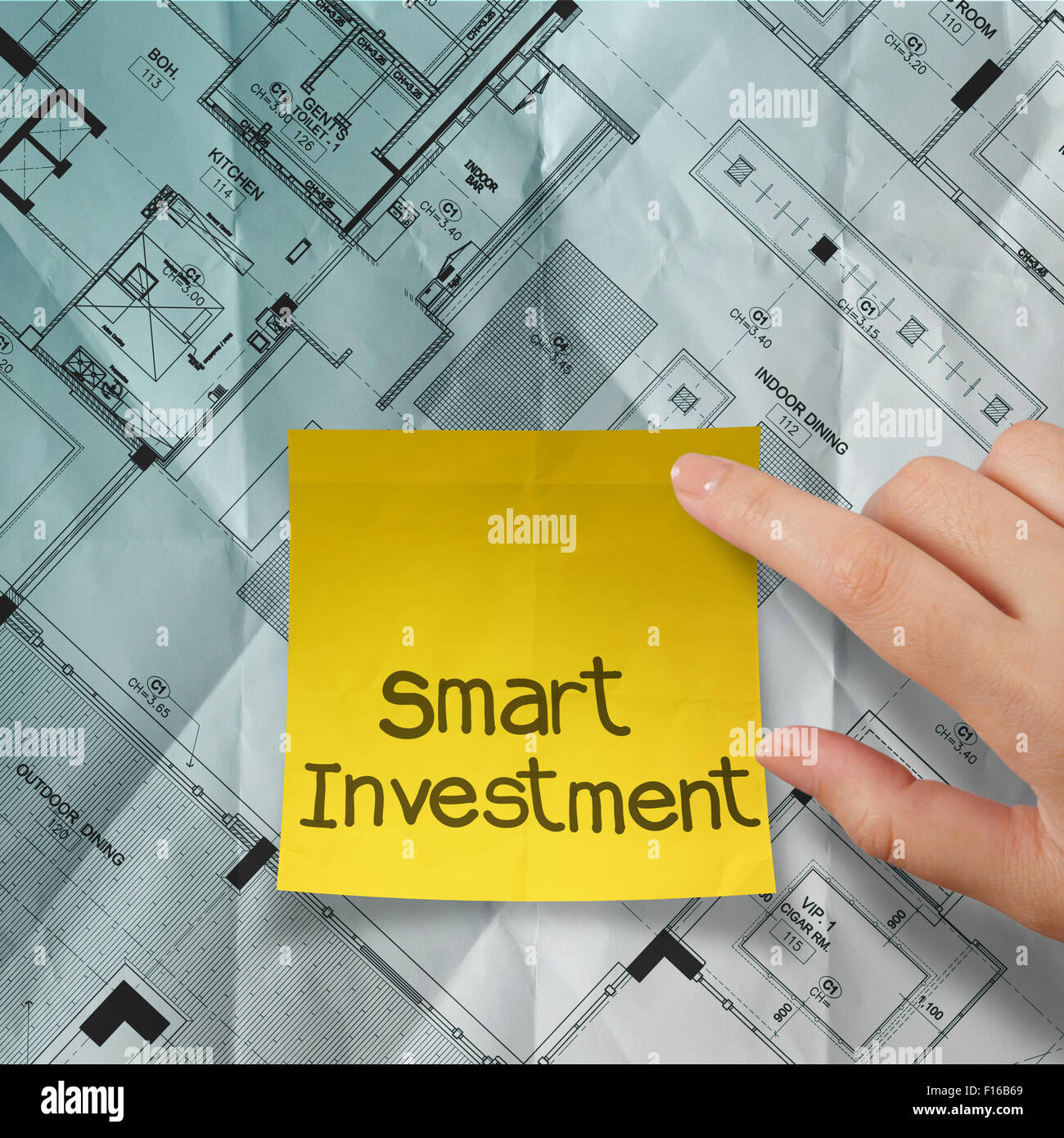 hand point smart investment sticky note with crumpled blue print part ...