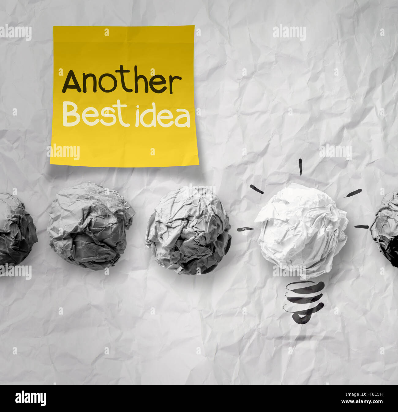 sticky note with another idea light bulb on crumpled paper as creative ...