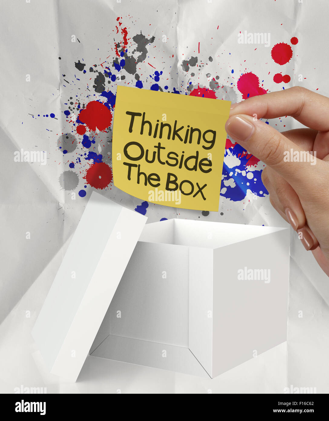 hand hold sticky note thinking outside the box and splash colors ...