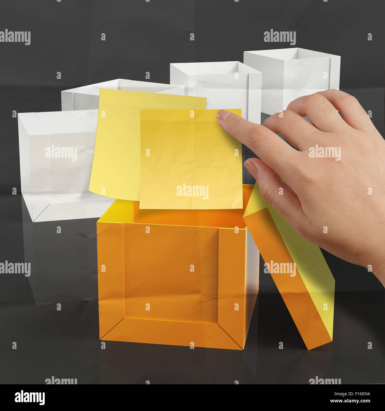 hand holding sticky note with thinking outside the box on dark crumpled ...