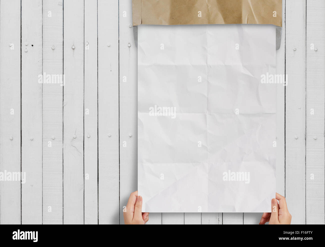 hand pulling crumpled paper from recycle envelope on white wood ...