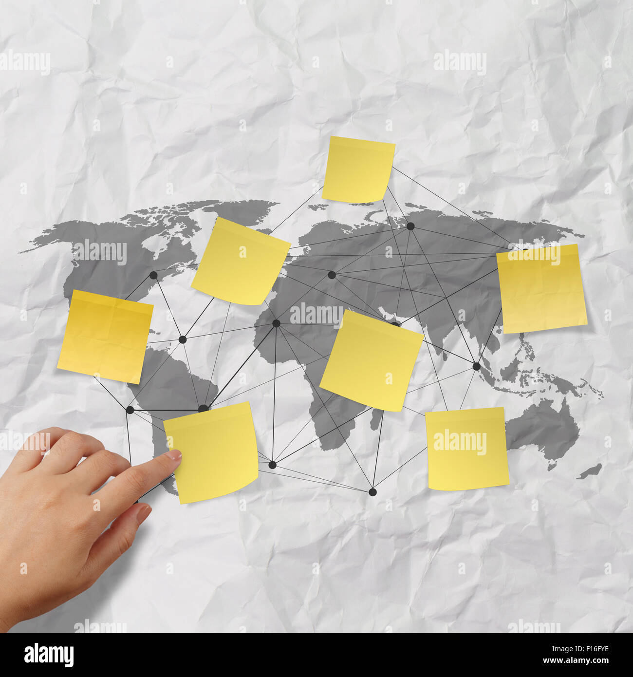 hand pushing sticky note social network icon on crumpled paper ...