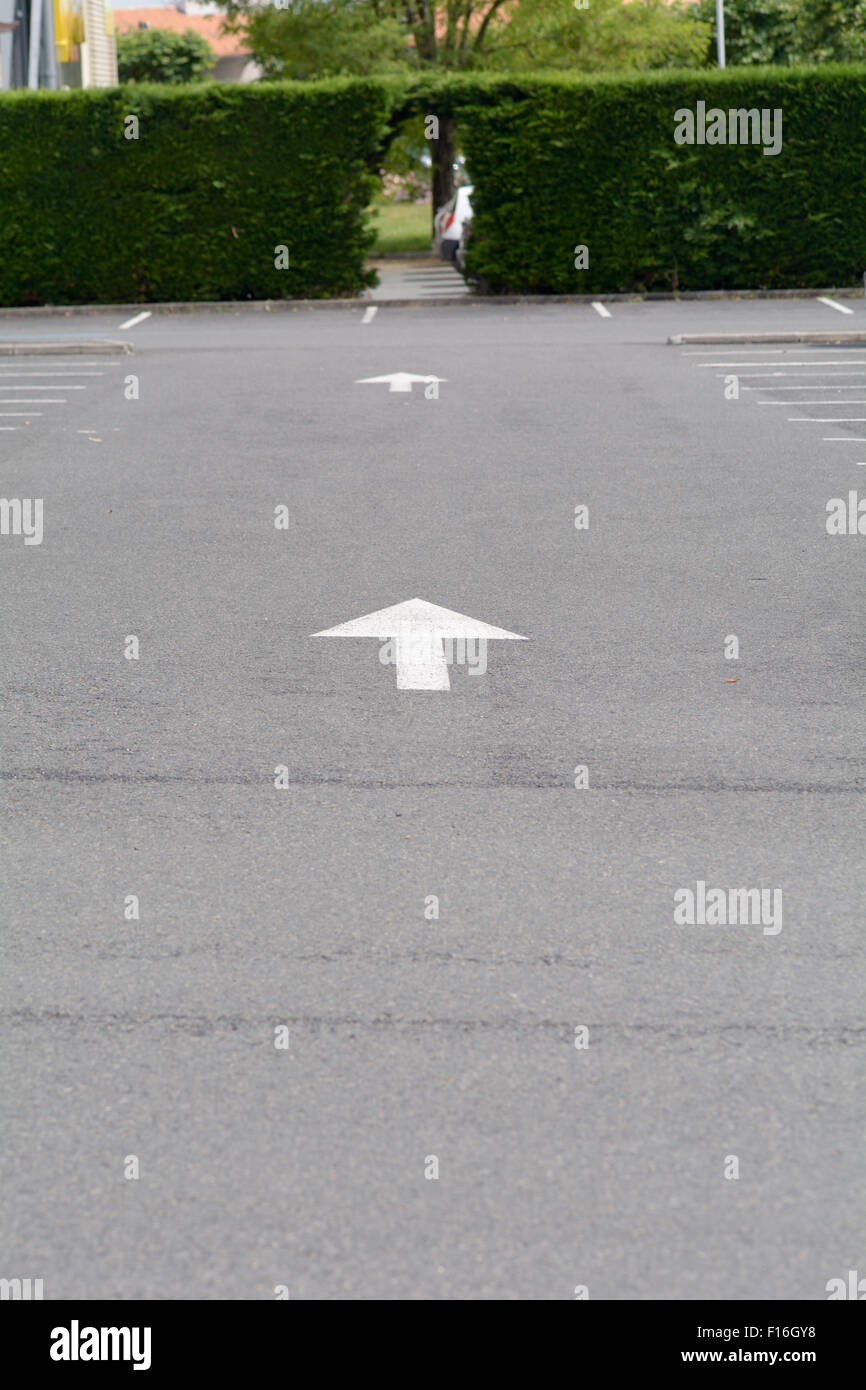 Direction arrows painted on tarmac in car park Stock Photo - Alamy