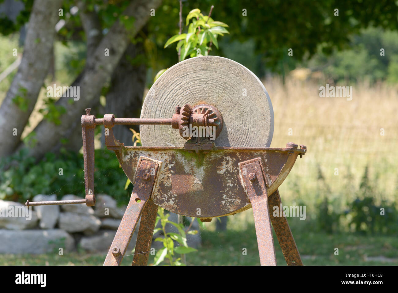 Circular sharpening stone with handle used to sharpen agricultural ...