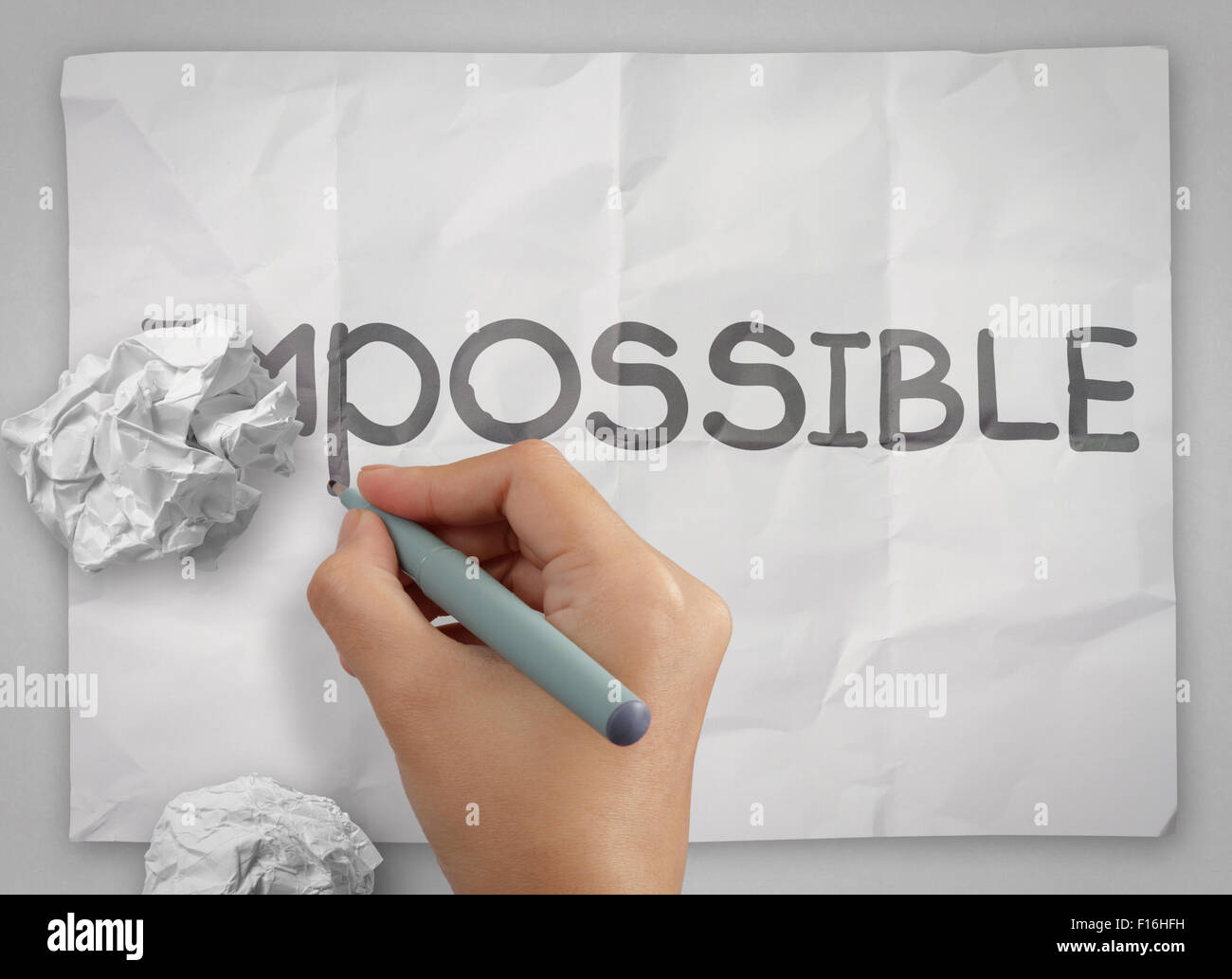 crumpled paper hiding word impossible transformed into possible as ...