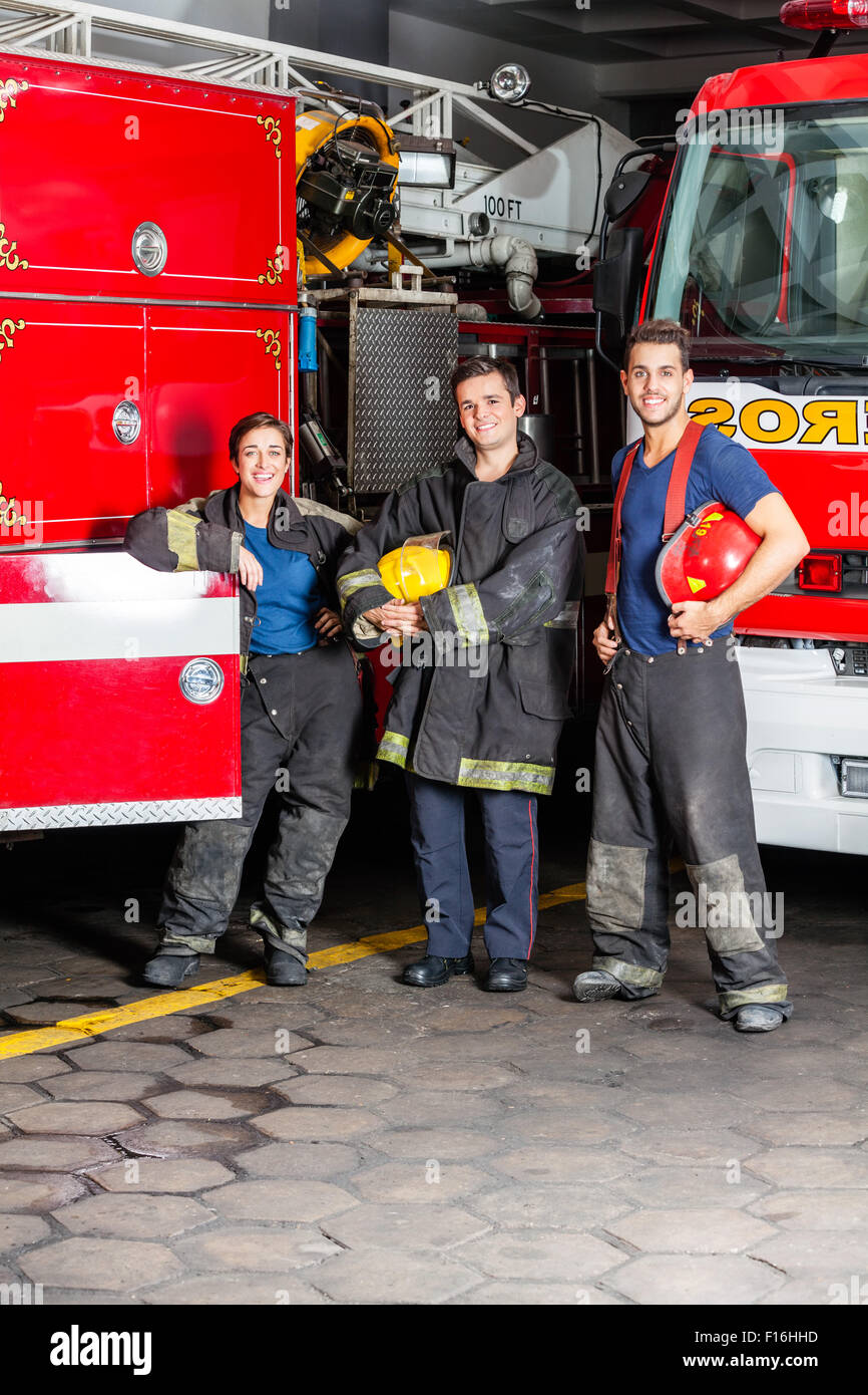 Happy Young Firefighters Standing Against Trucks Stock Photo - Alamy