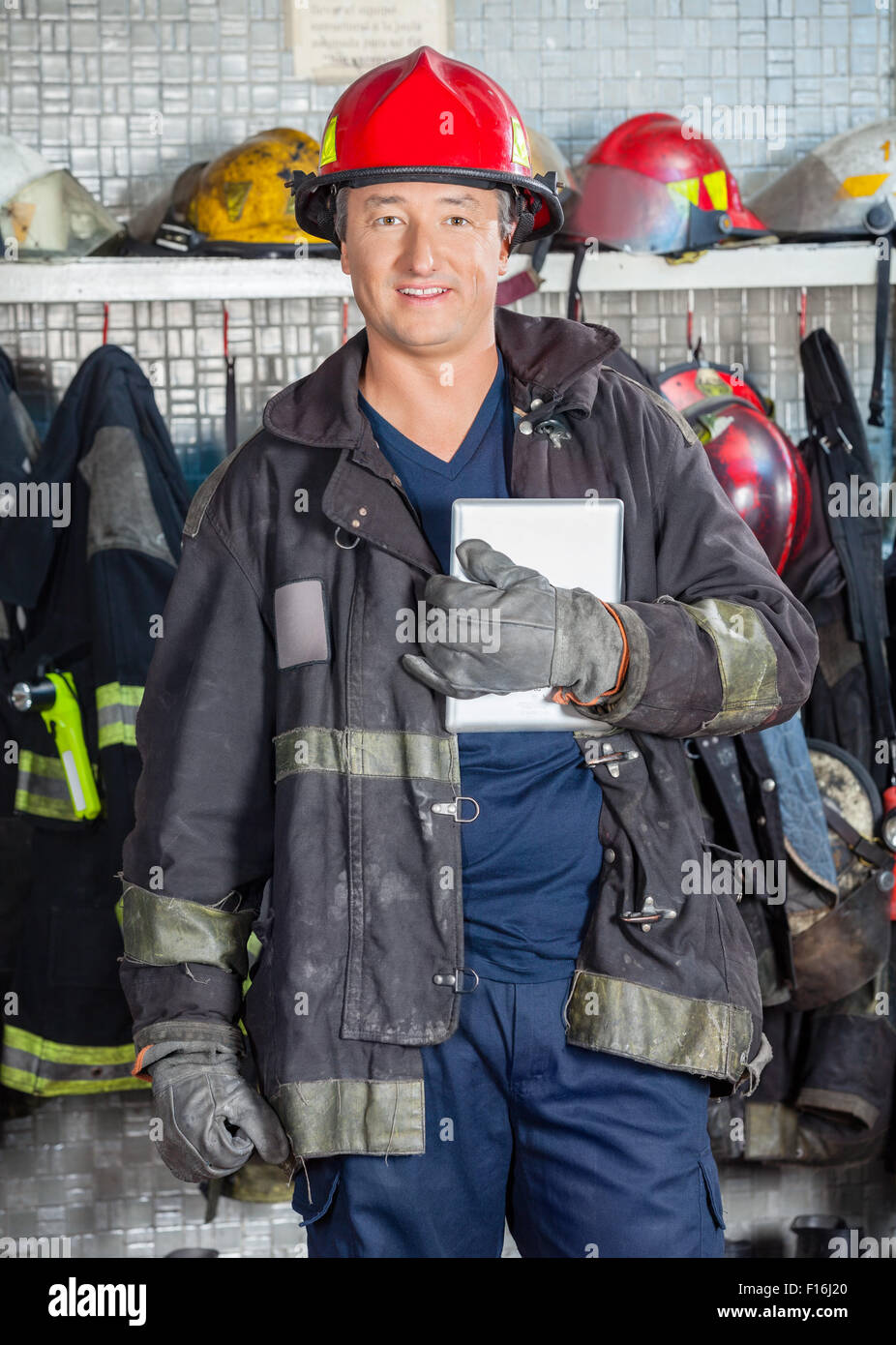 Smiling Worker Holding Digital Tablet At Fire Station Stock Photo - Alamy