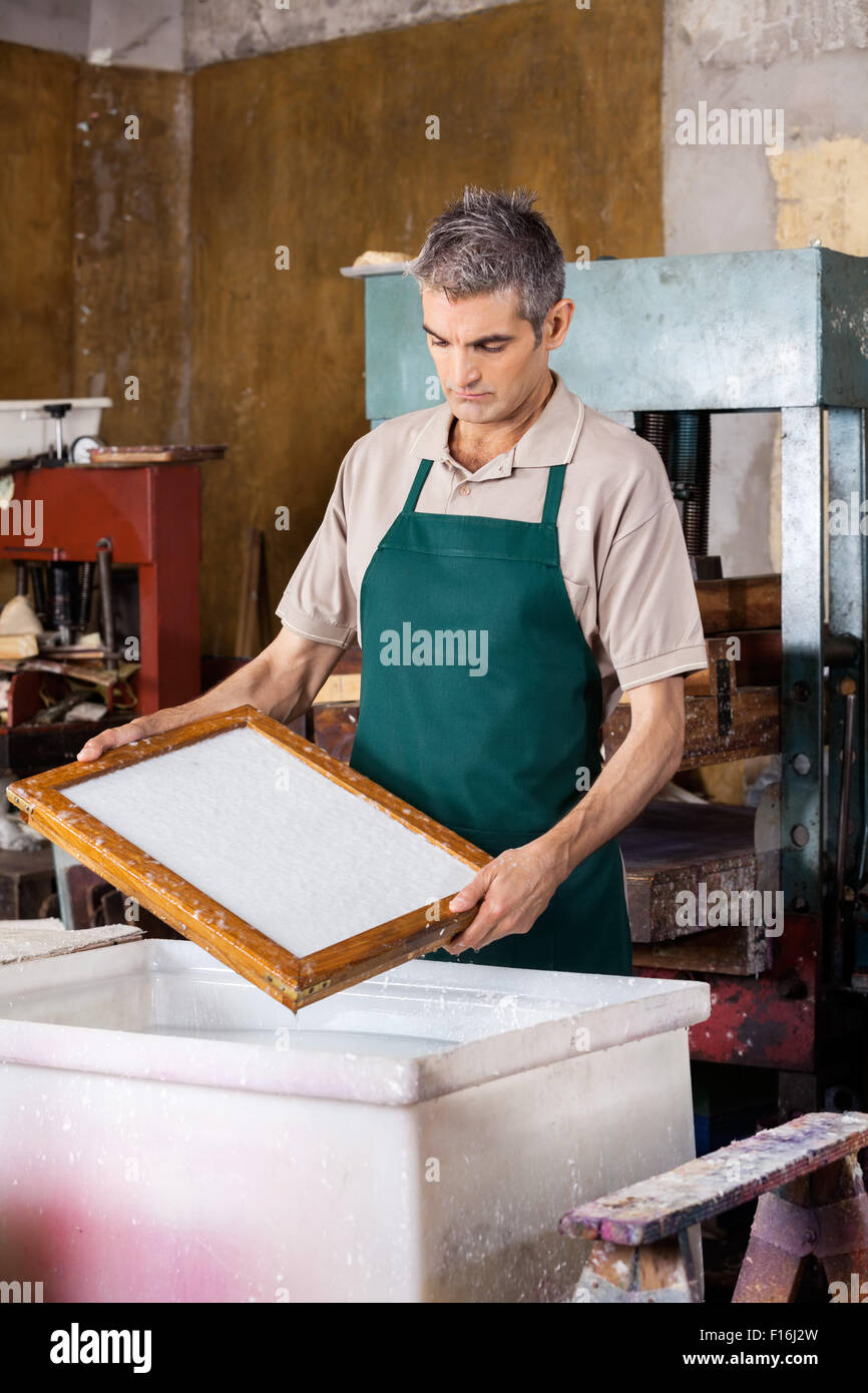 Worker Holding Mold Over Pulp And Water Mixture Stock Photo - Alamy