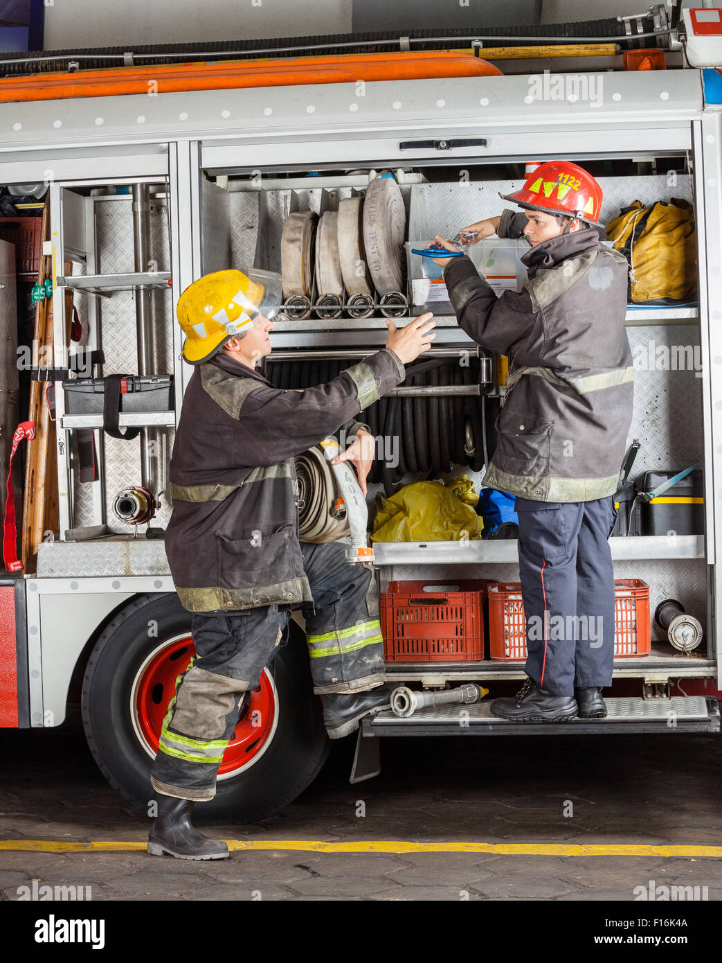 Male Firefighters Working At Truck Stock Photo - Alamy