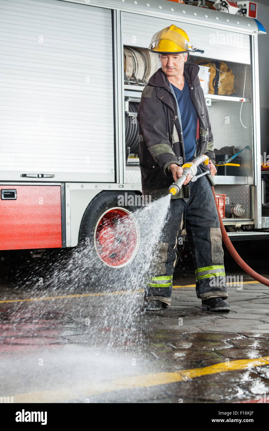 Fireman Spraying Water On Floor During Practice Stock Photo - Alamy