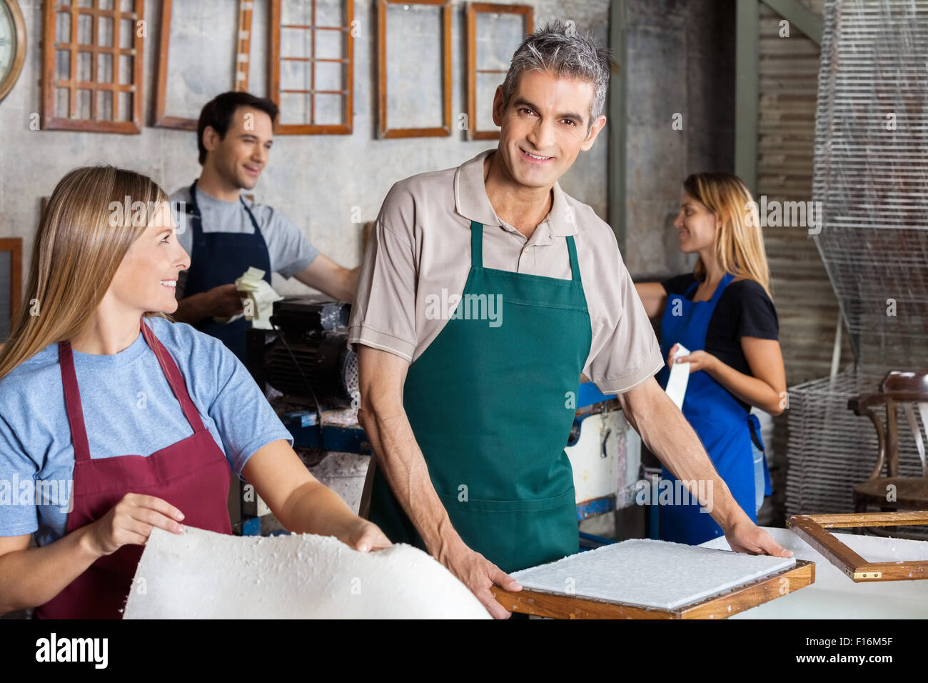 Smiling Man Making Papers With Colleagues In Factory Stock Photo - Alamy
