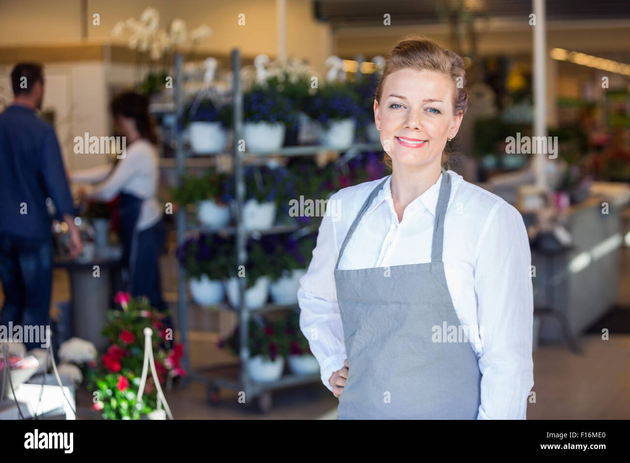 Portrait Of Smiling Female Salesperson In Flower Shop Stock Photo - Alamy