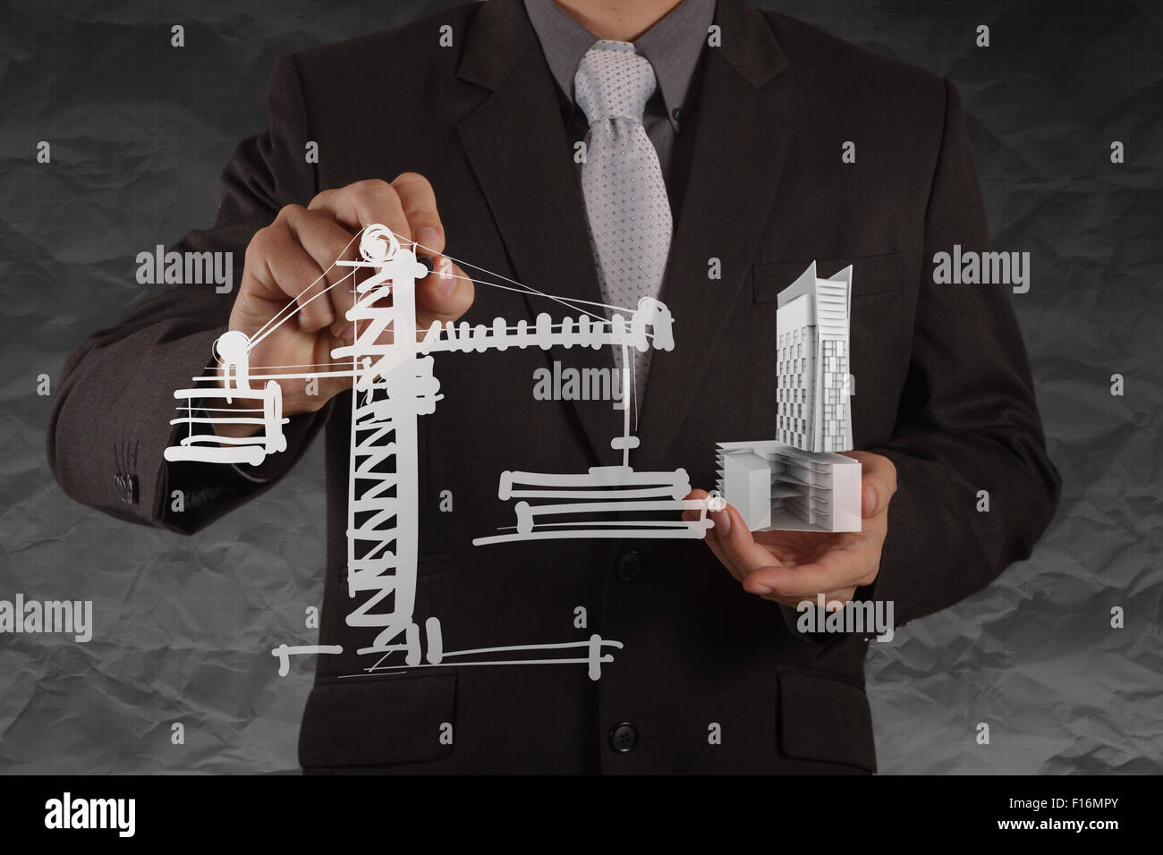 businessman hand shows house model with crumpled paper background as ...